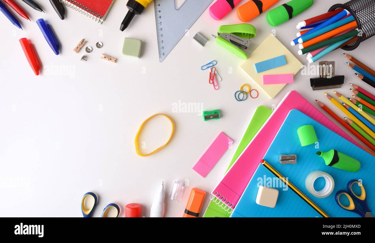 Assortment of colorful school supplies on white desk. Top view ...