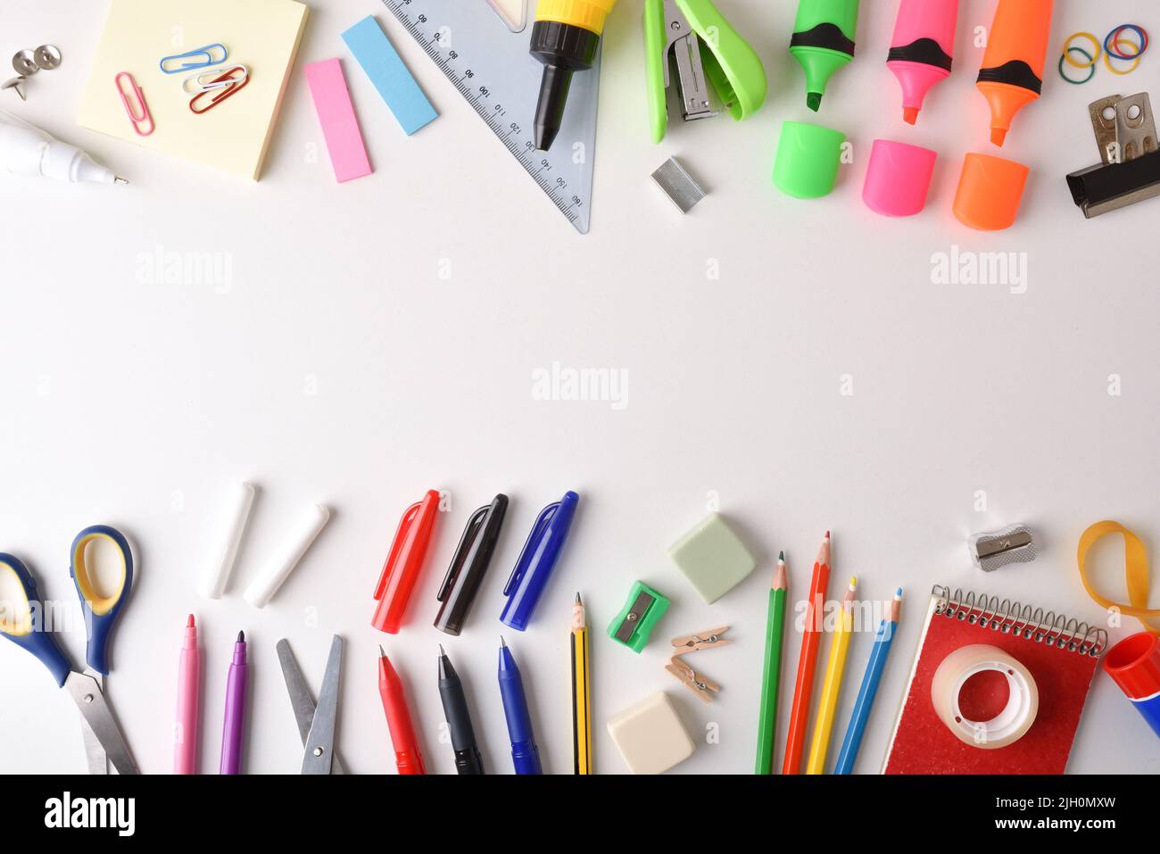 Assortment of colorful school supplies arranged on white table. Top ...
