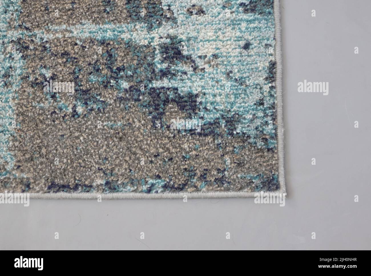 Part of a dirty carpet on a grey floor, many hairs of a dog or cat ...