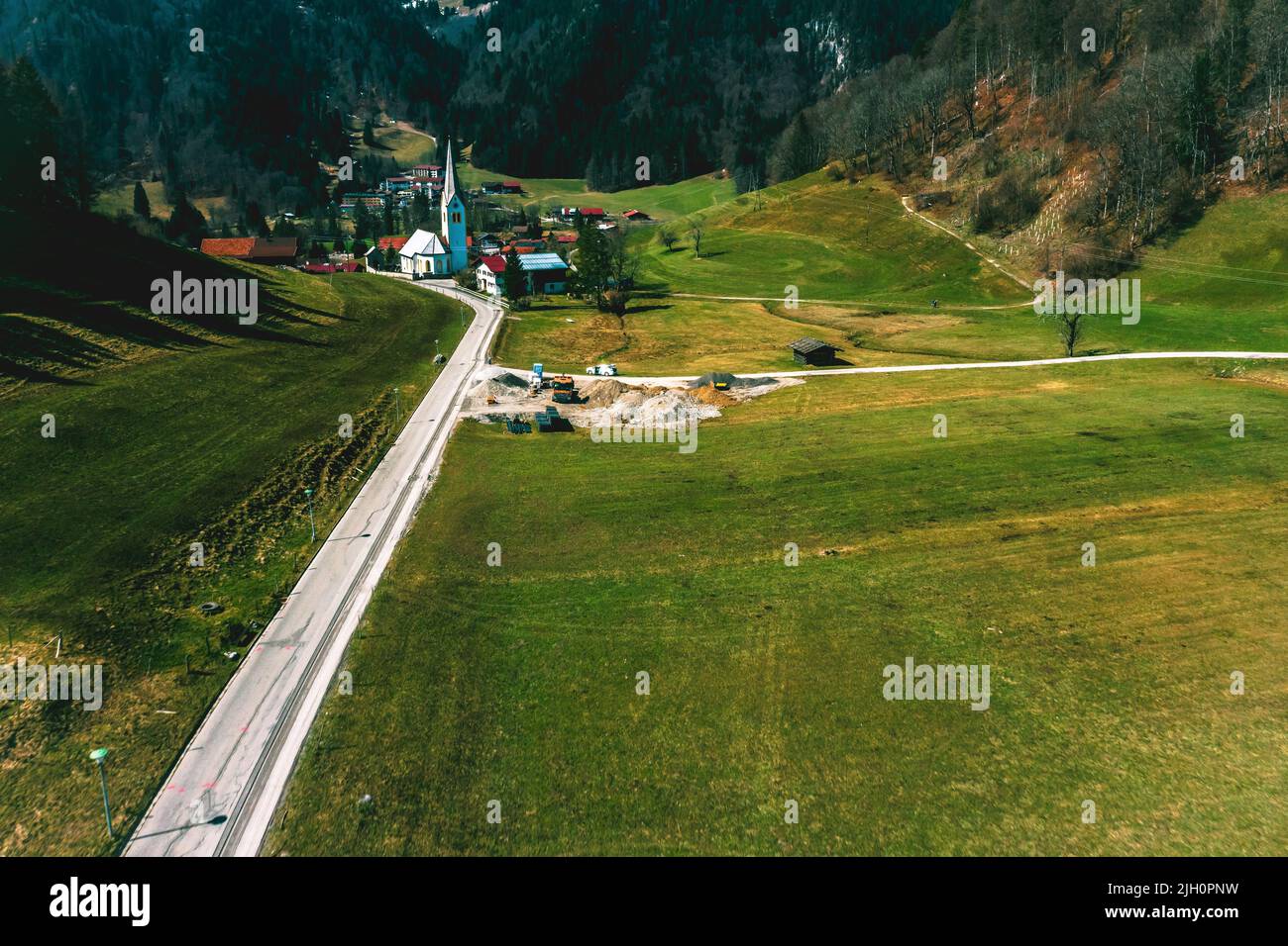 The aerial view of a church in the green field against the forest Stock ...
