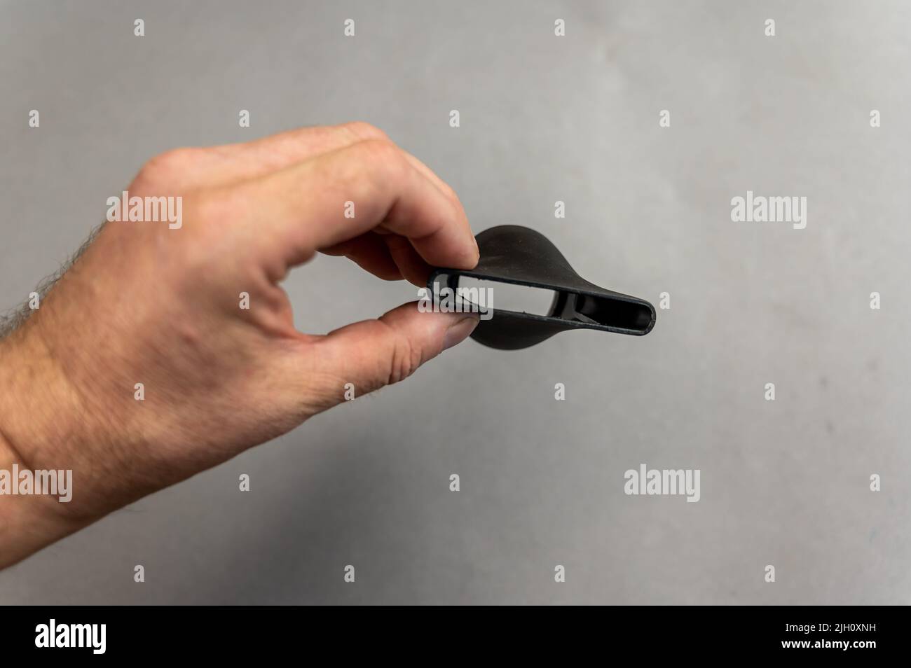 The man is holding the concentrator nozzle for the electric hair dryer ...