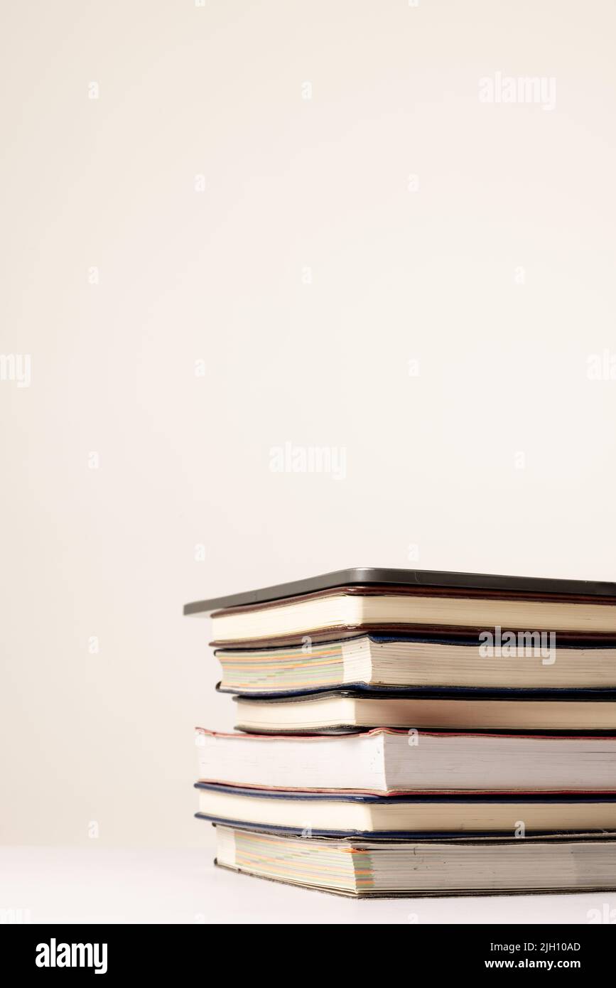 Vertical image of stack of books on beige surface Stock Photo - Alamy