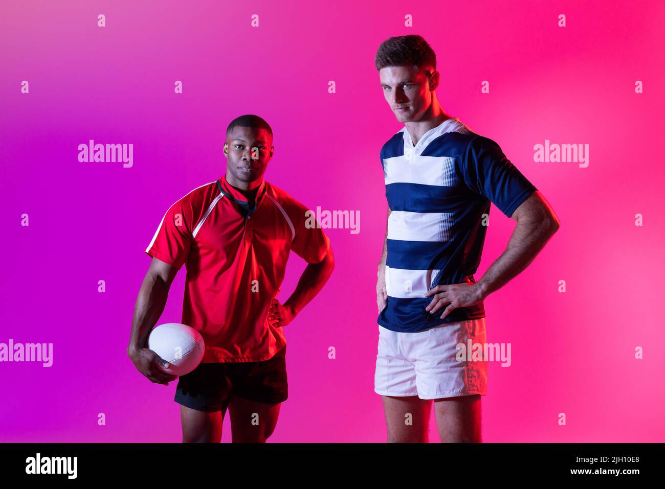 Portrait of diverse male rugby players with rugby ball over pink ...