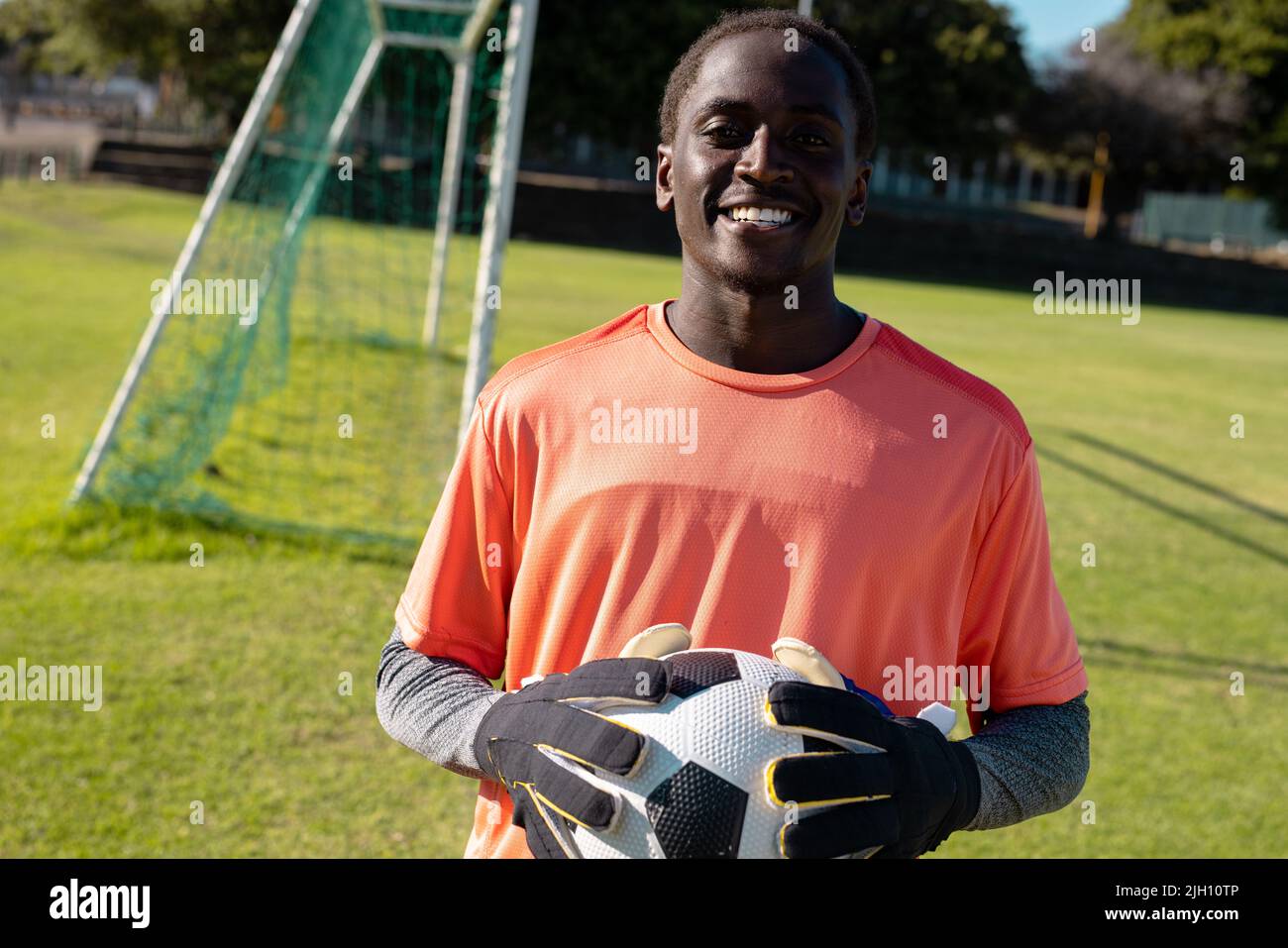 Portrait of smiling african american young male goalkeeper wearing ...