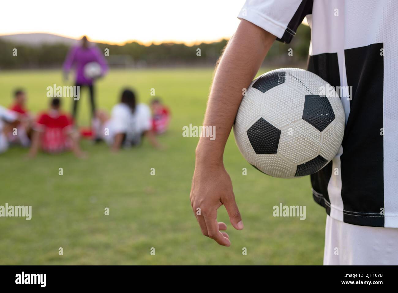 Midsection of caucasian male player in white uniform with soccer ball ...