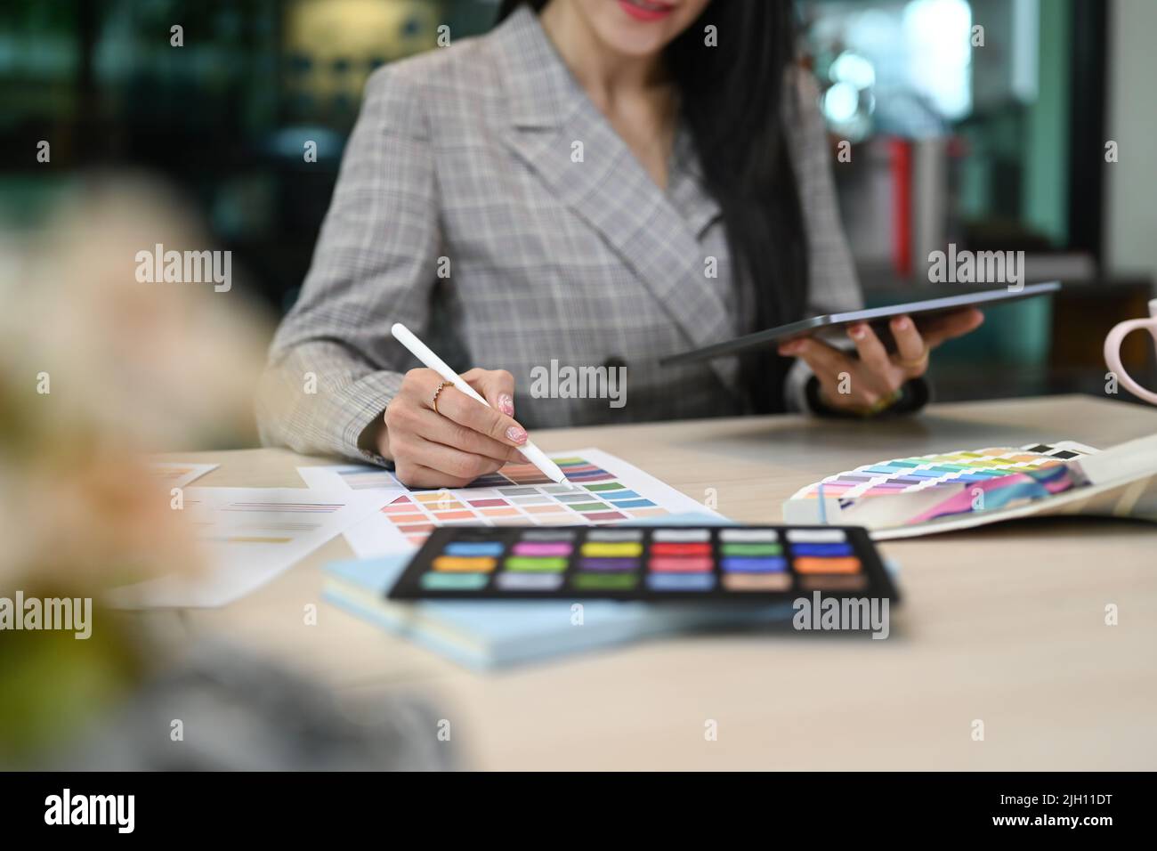 young woman interior designer working with color swatches and using ...