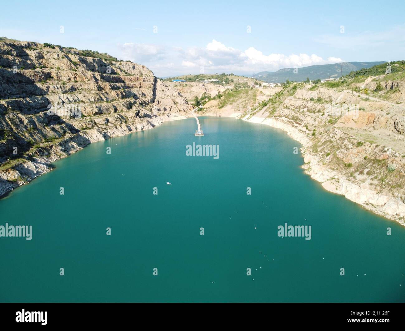 Aerial top view on opencast mining quarry with flooded bottom ...