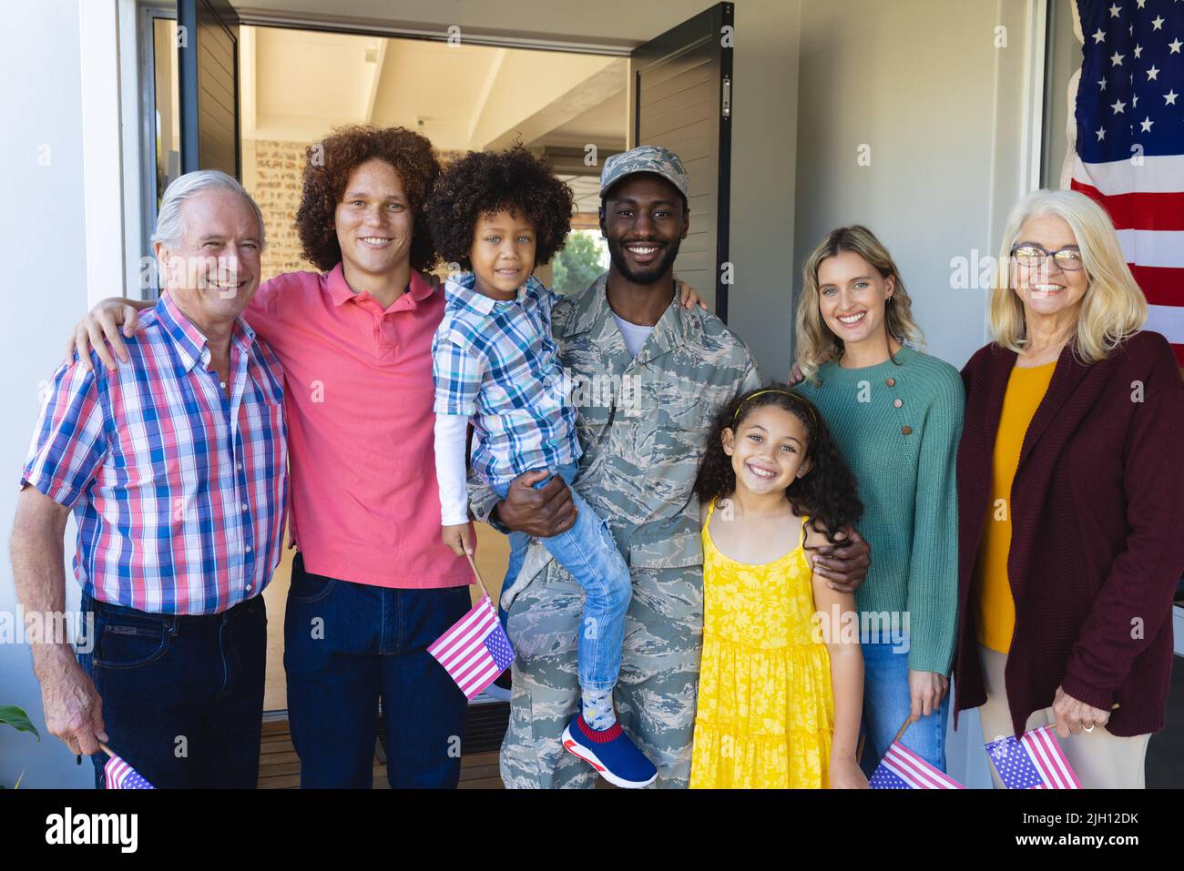 Portrait of smiling multiracial soldier with multigeneration family ...