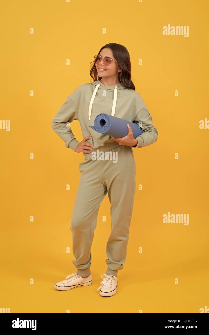full length of happy child in sportswear and sunglasses with fitness ...