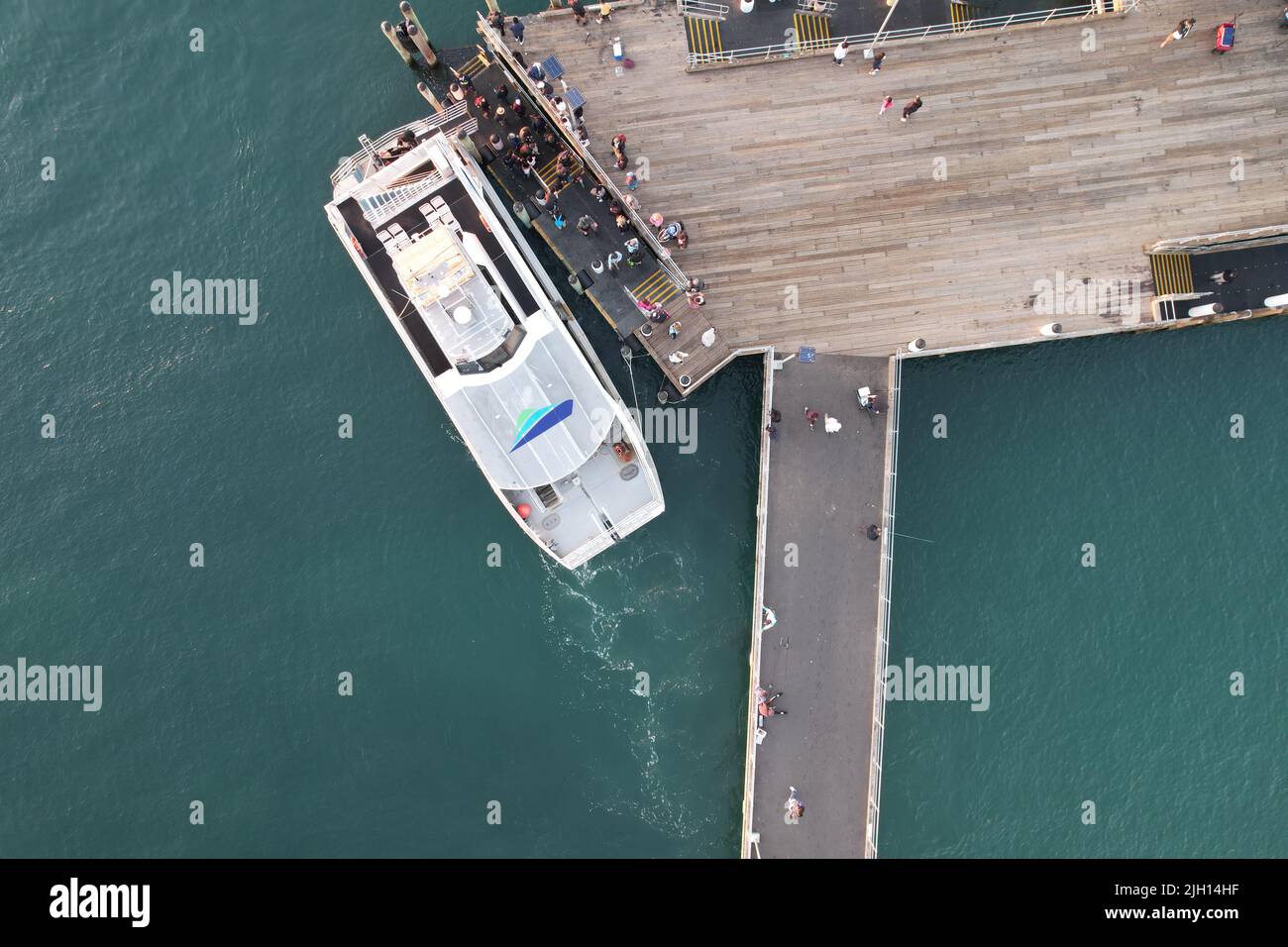 A top view of a boat moored at a pier with people on Philip Island ...