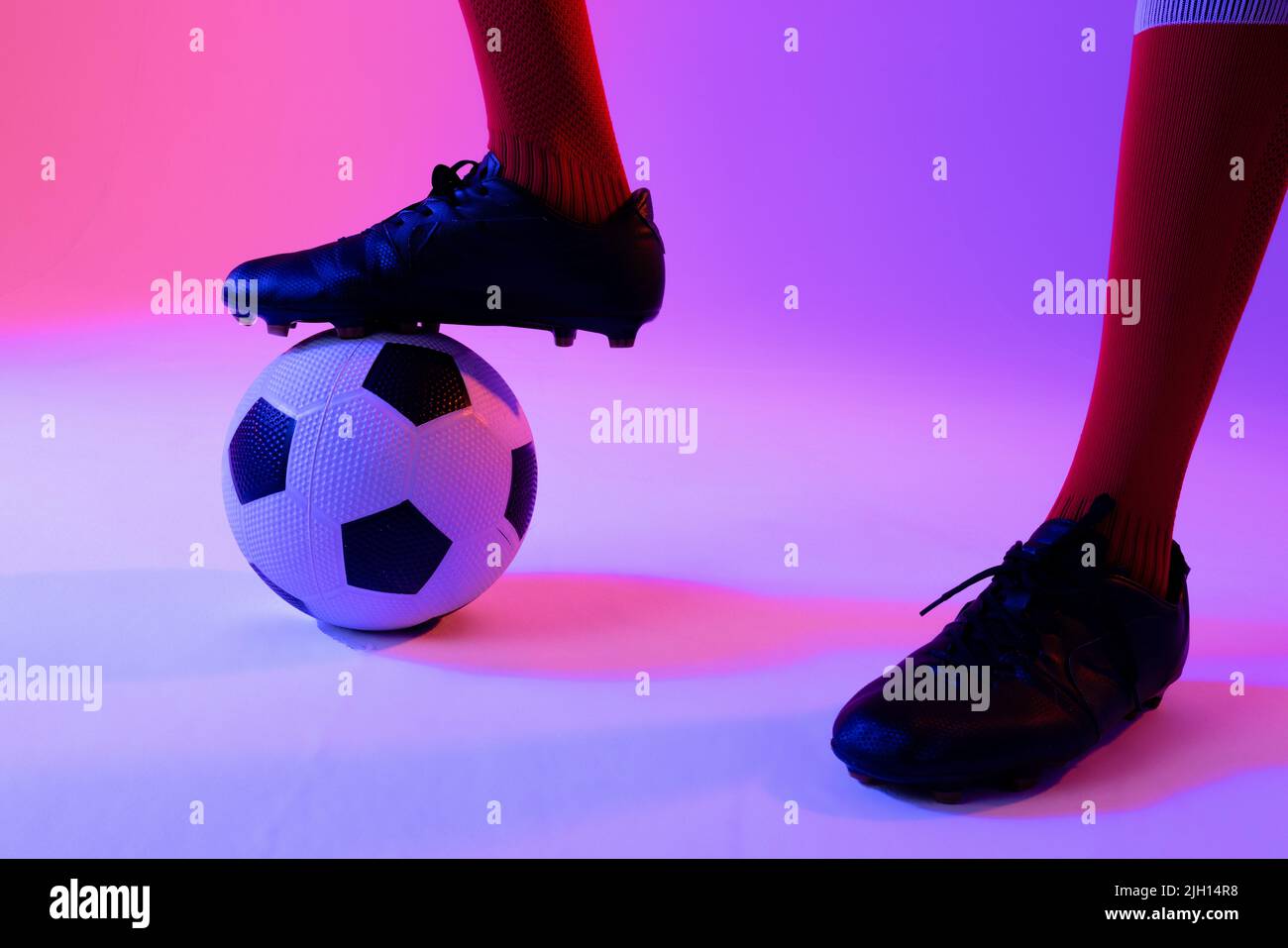 Male soccer player with football over neon pink lighting Stock Photo ...