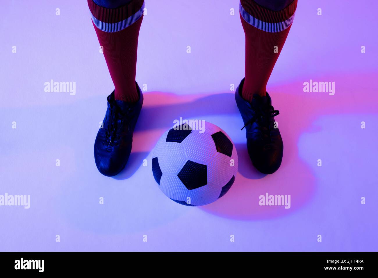 African american male soccer player with football over neon pink ...