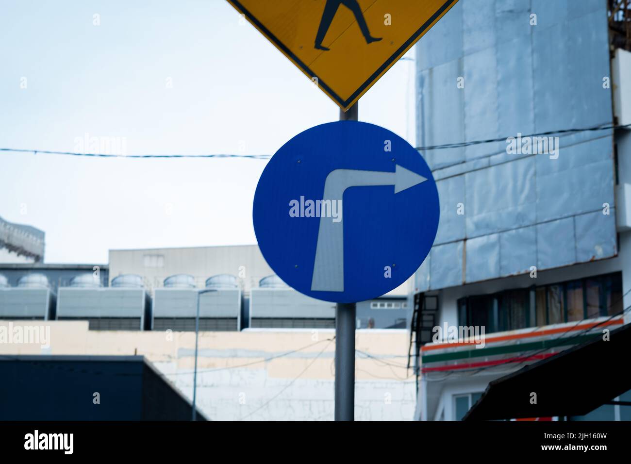 The close-up view of a blue circular street sign showing to turn right ...