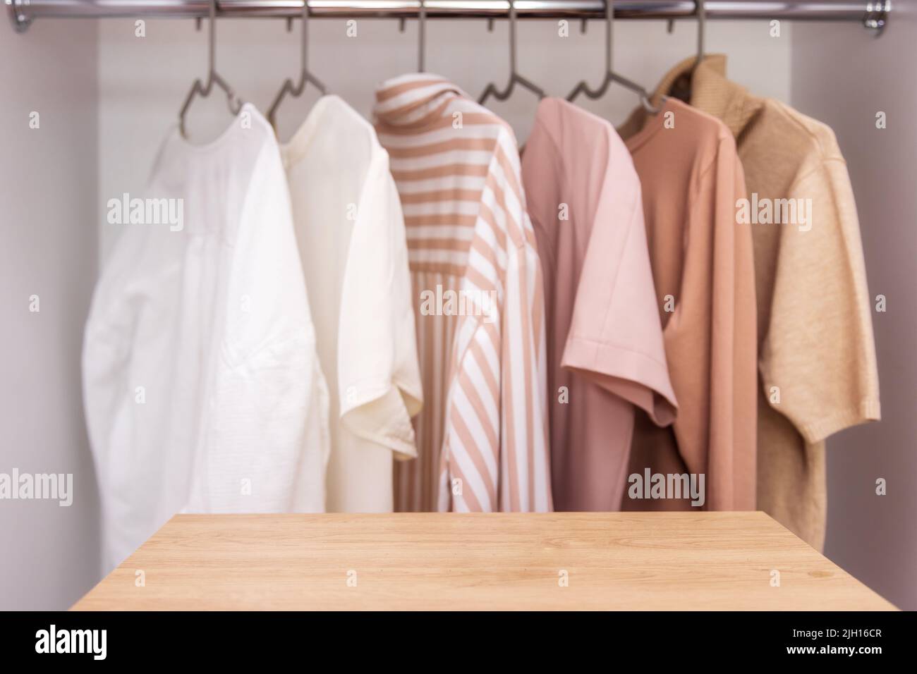 Mockup against background of wardrobe with clothes in neutral colors ...