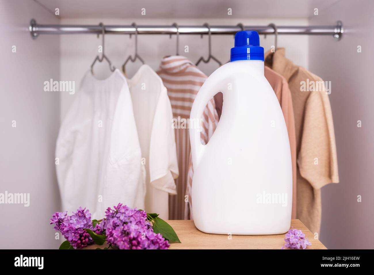 White detergent bottle mockup against the background of a wardrobe with ...