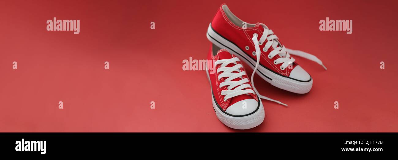 Pair of modern stylish red sneaker shoes, white and red colours mix ...
