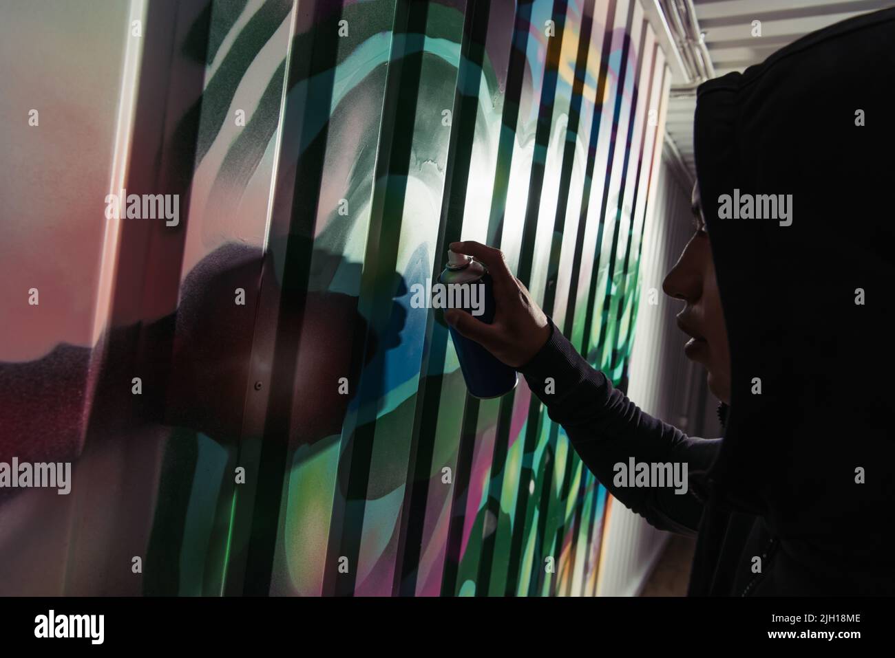 Side view of african american vandal drawing graffiti on wall Stock ...