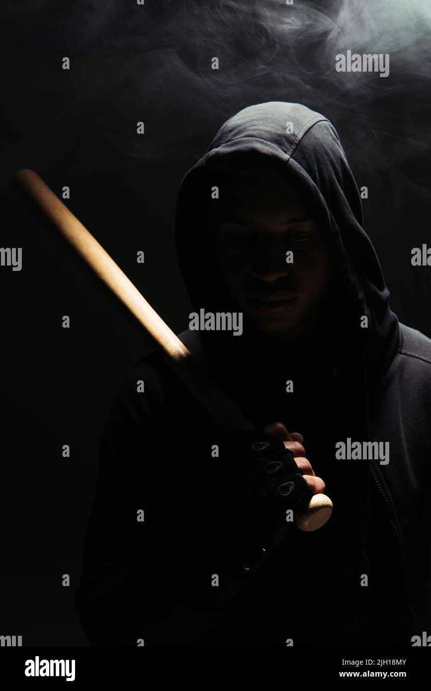 Silhouette of african american bandit in hood and glove holding ...