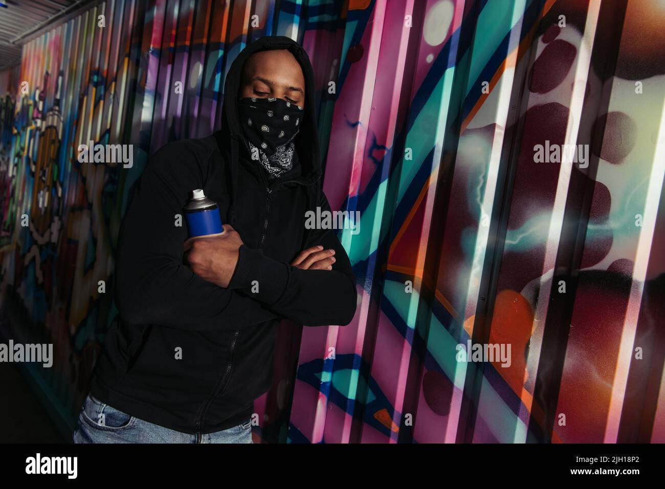 African american vandal with mask on face holding spray paint near ...