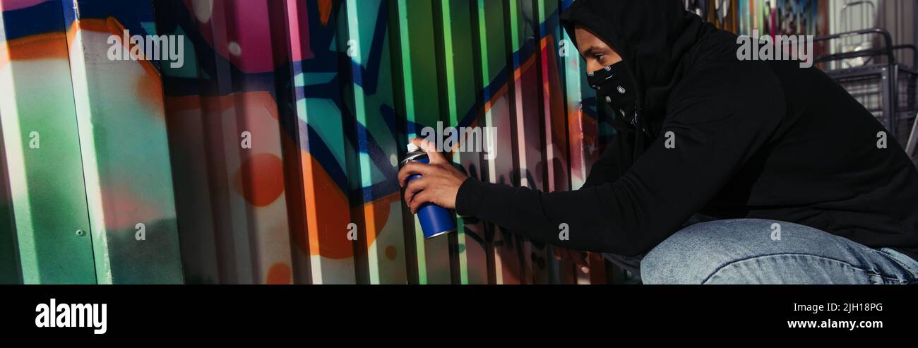 Side view of african american vandal with obscured face drawing ...