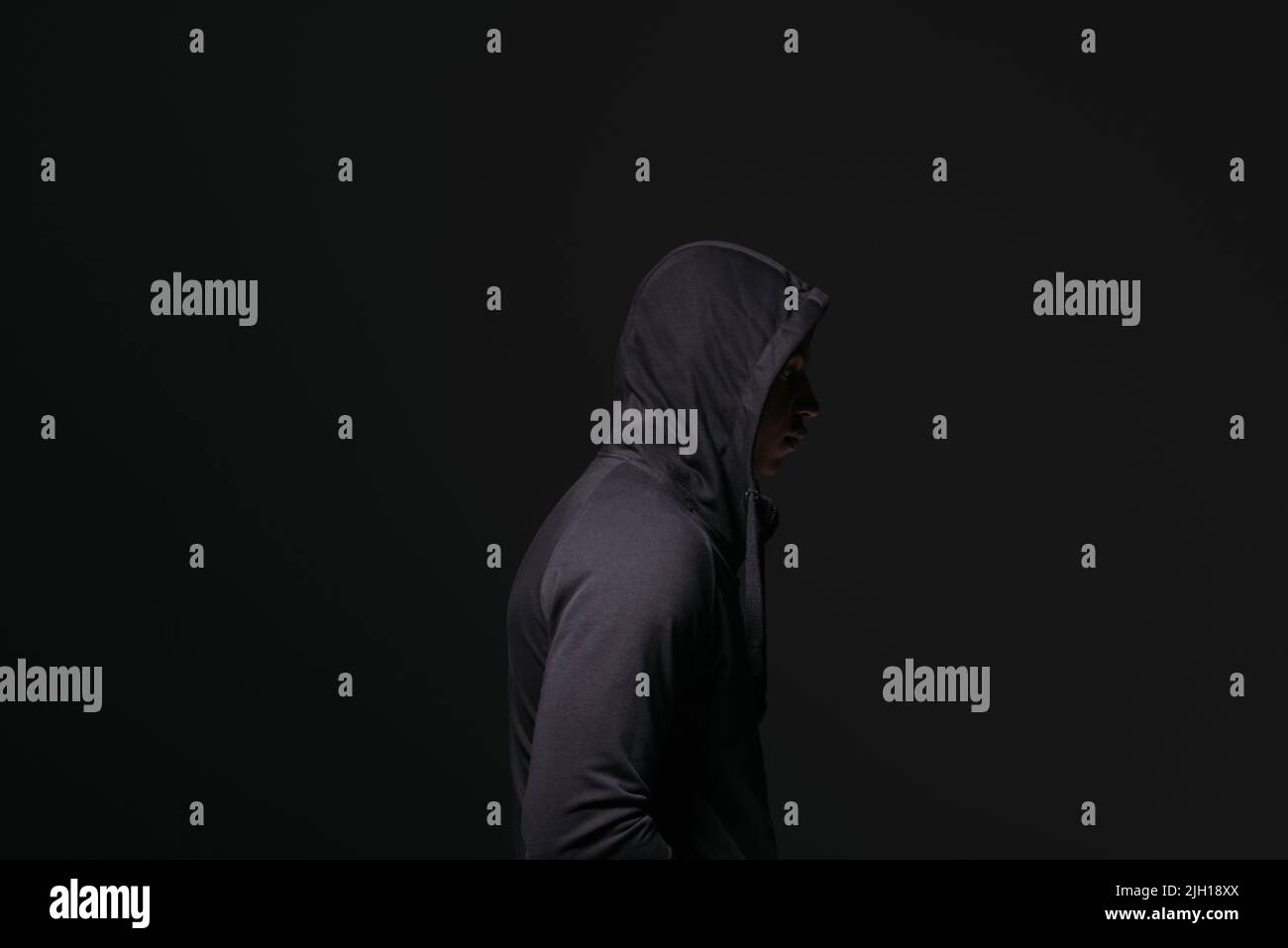 Side view of african american hooligan in hood standing isolated on ...