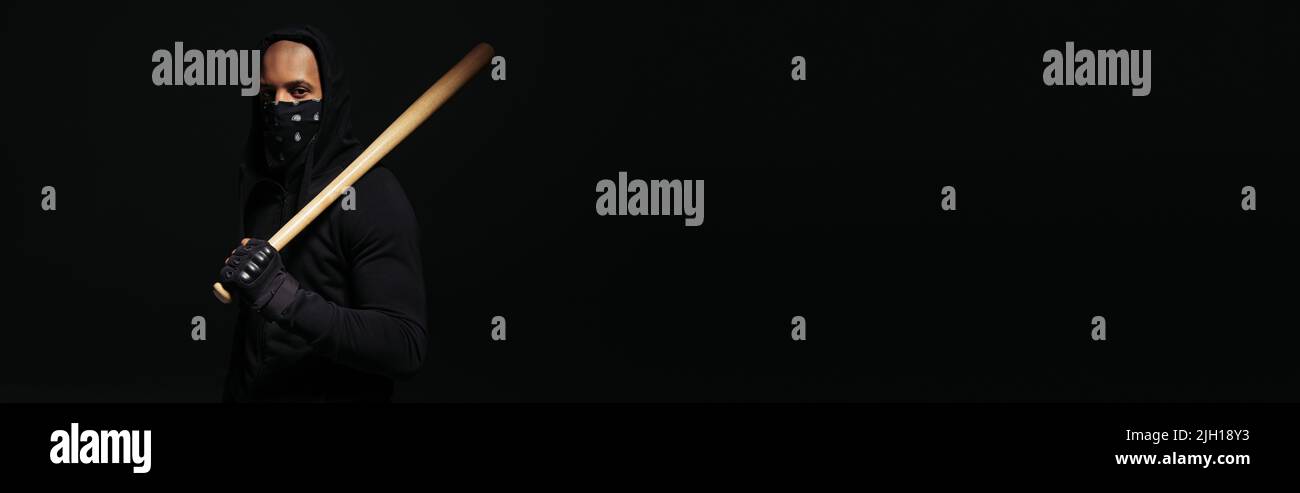 African american hooligan with mask on face holding baseball bat ...