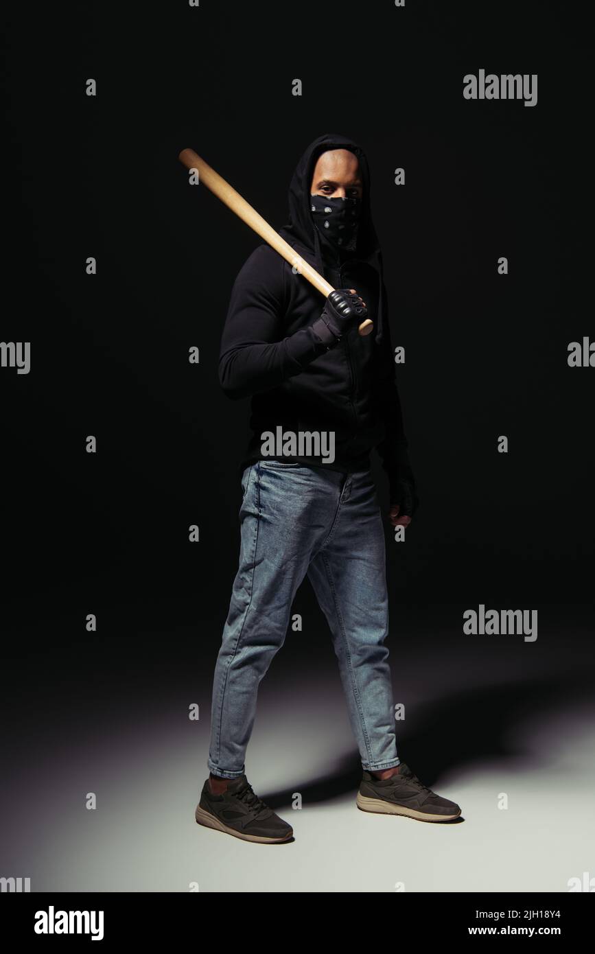 Full length of afrcan american hooligan in mask on face holding ...