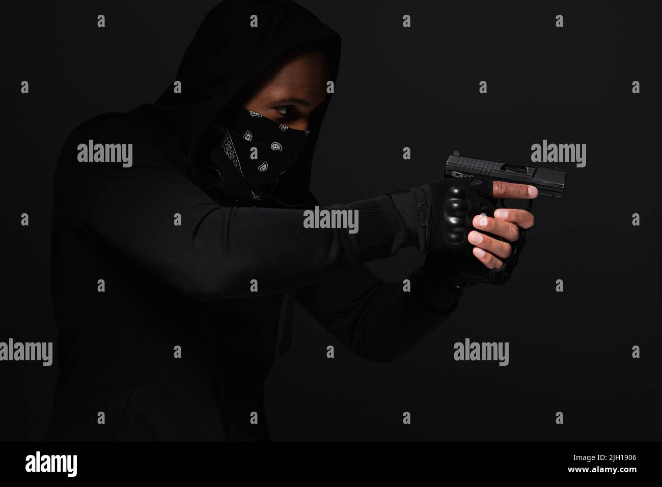 African american bandit in mask holding handgun isolated on black Stock ...