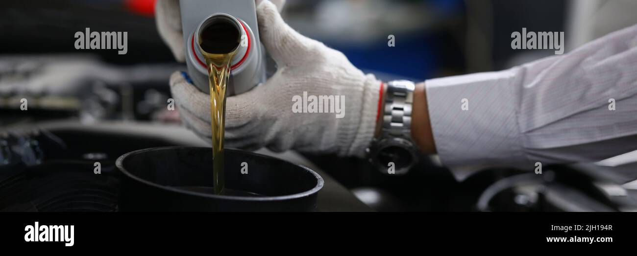 Worker refueling and pouring new oil into engine motor car Stock Photo ...