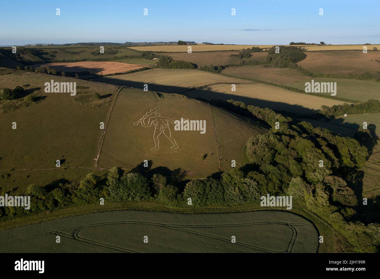 Ancient Chalk Giant figure on hillside above village of Cerne Abbas ...