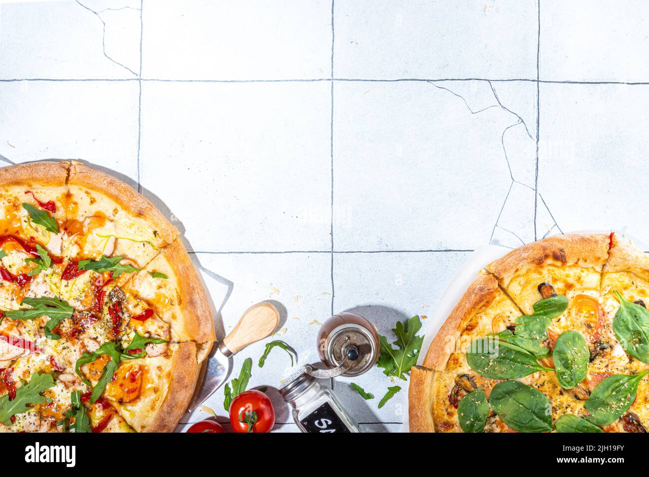 Three various pizzas, served at home or in restaurant on tiled table ...