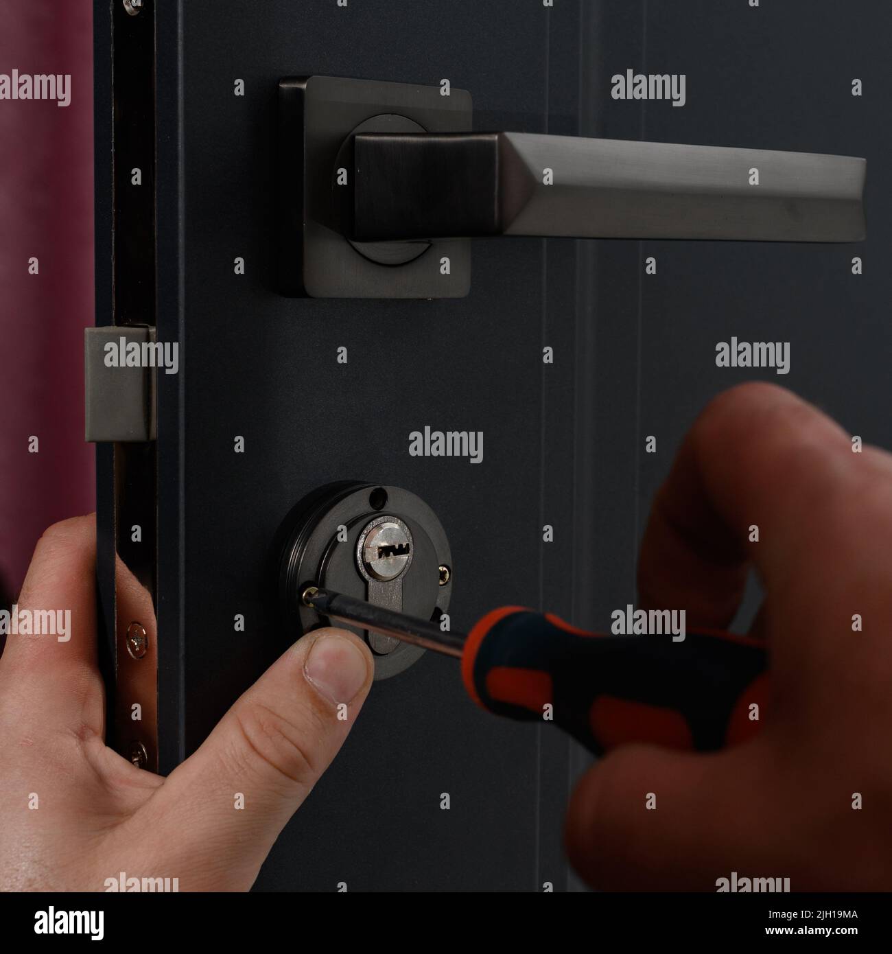Installation of a door lock, a carpenter installs a door lock in a door ...