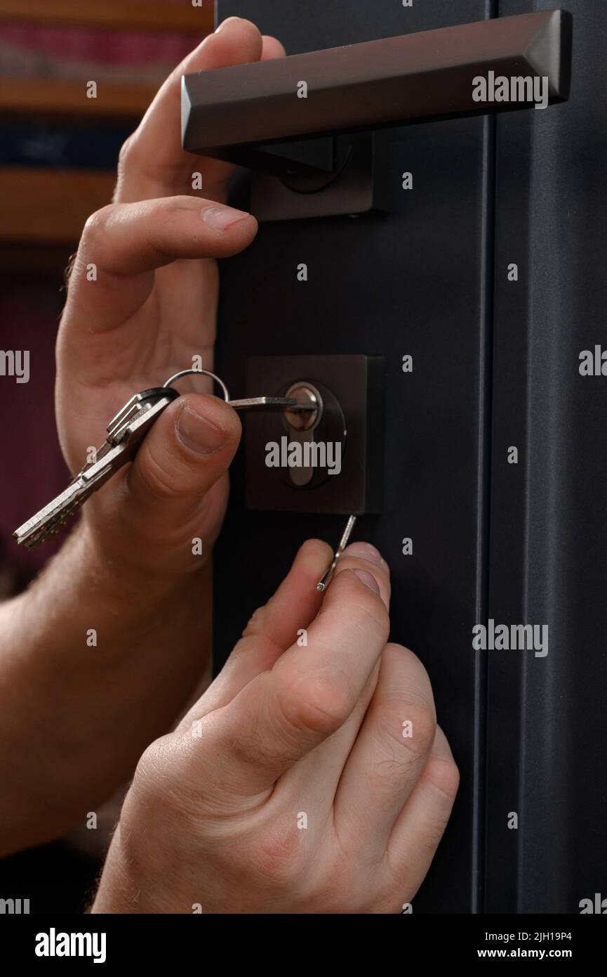 Installation of a door lock, a carpenter installs a door lock in a door ...