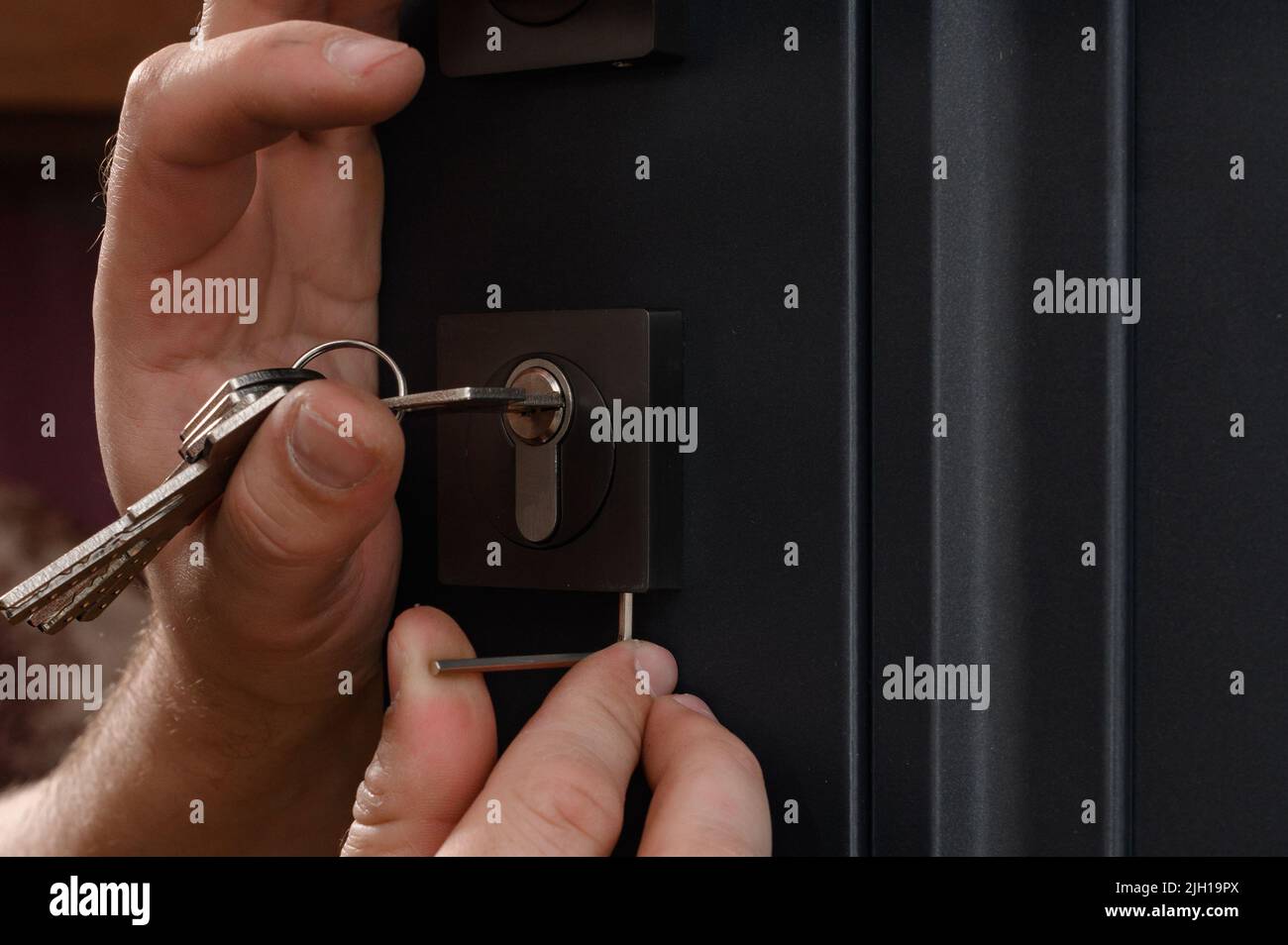 Installation of a door lock, a carpenter installs a door lock in a door ...