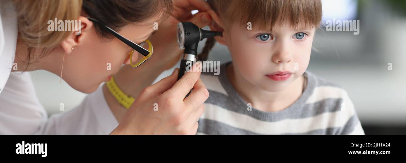 Little girl sit calm while family doctor examine ears with special ...
