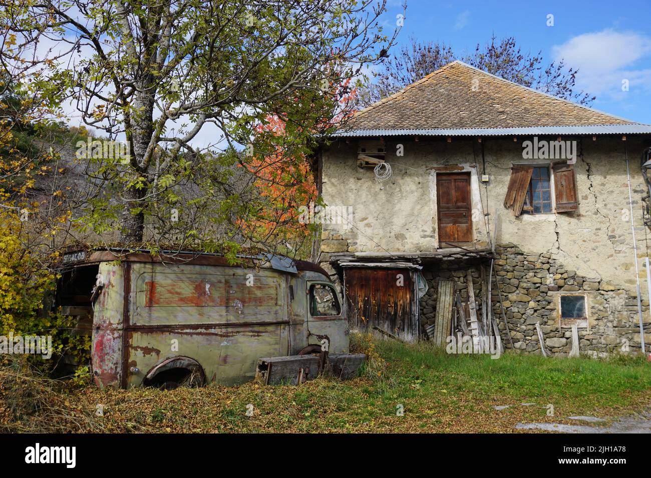 old destroyed abandoned rusty van by an old stone house in france Stock ...