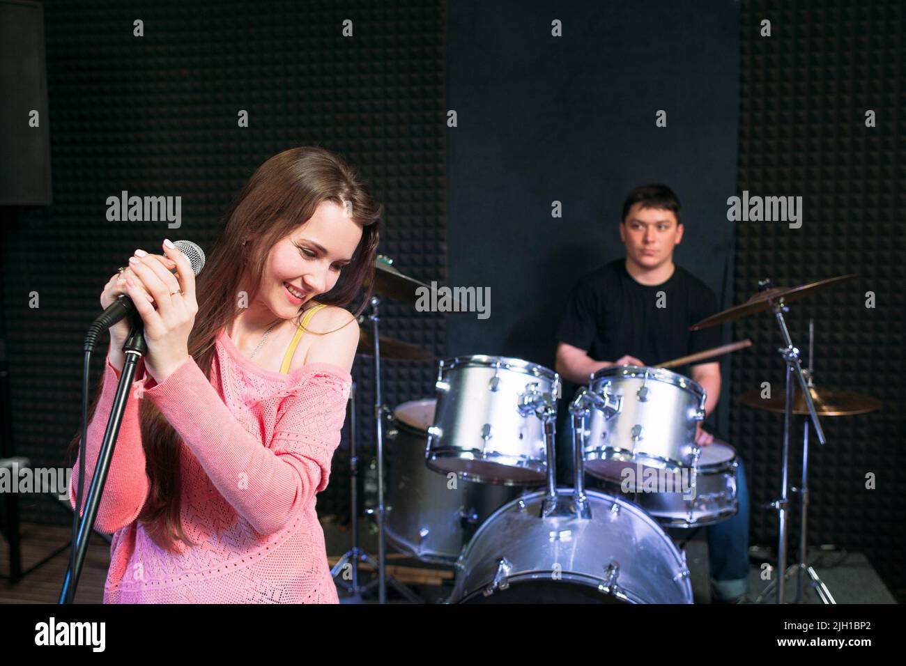 Shy female singer near microphone on scene Stock Photo - Alamy