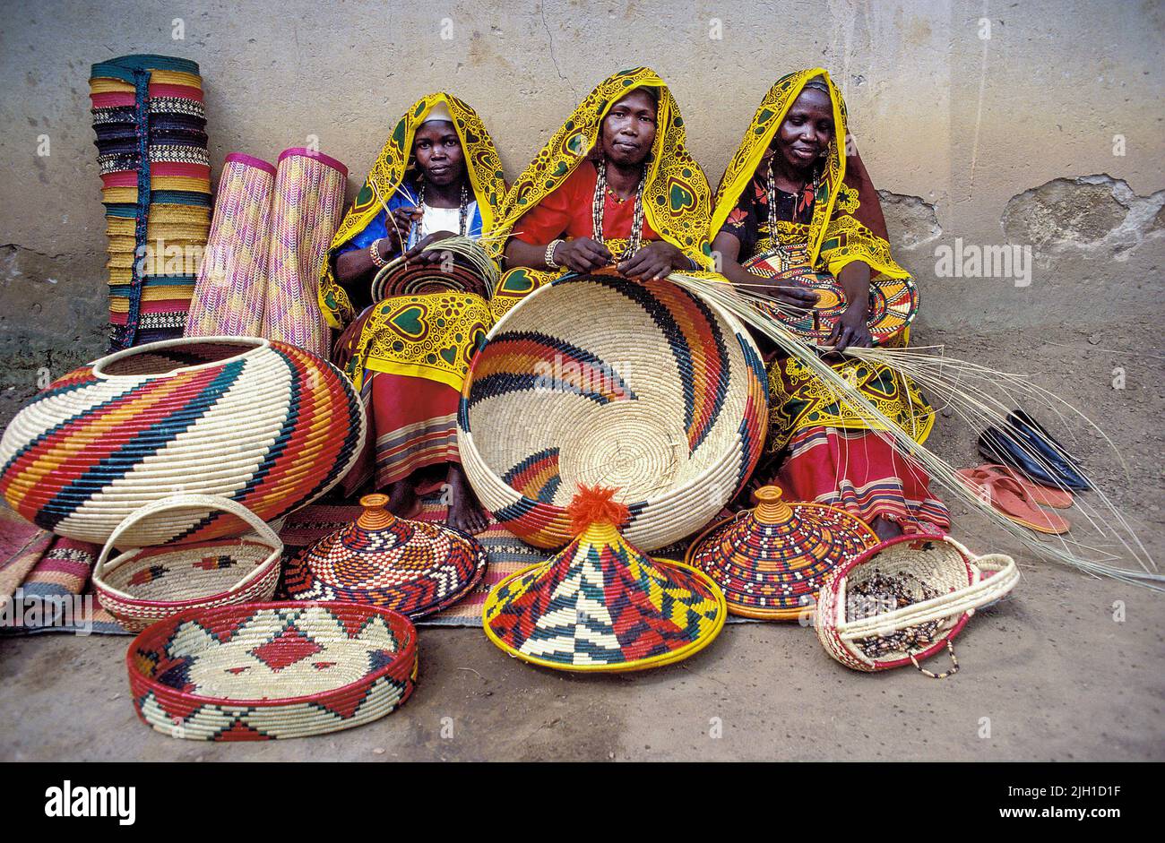 Uganda, Mbarara; Women in traditional clothing weaving baskets; this ...