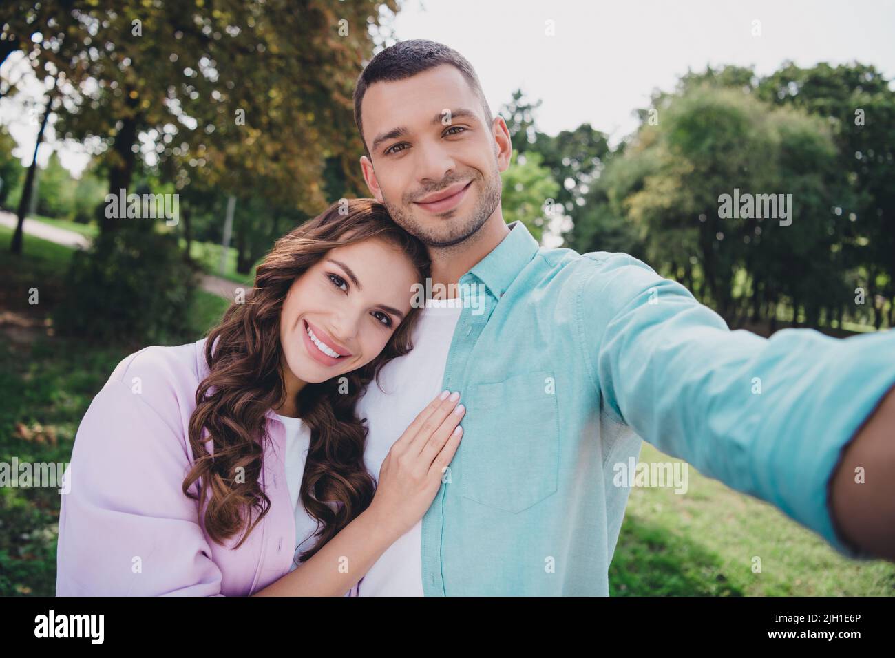 Photo of two idyllic positive people take selfie record video cuddle ...