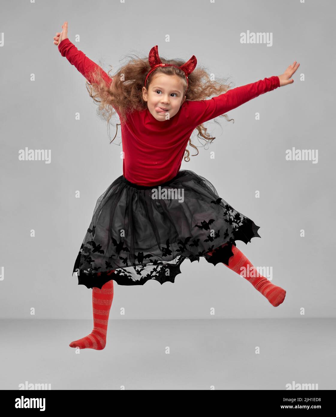 girl in halloween costume of devil jumping Stock Photo - Alamy