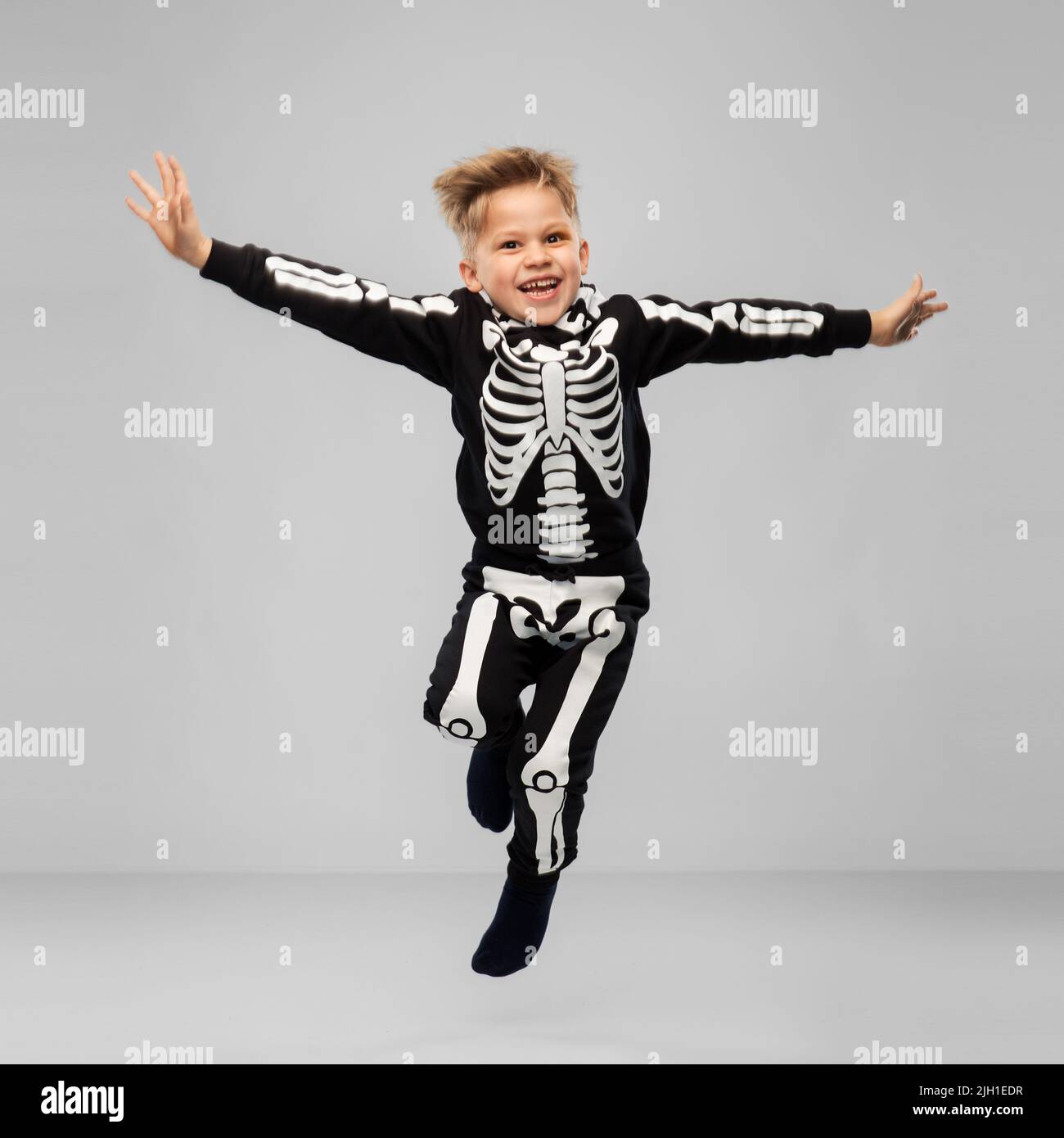 happy boy in halloween costume of skeleton jumping Stock Photo - Alamy