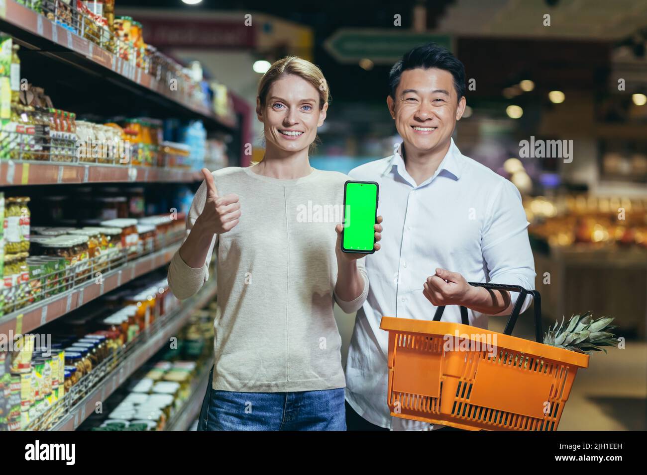 Portrait of a happy Asian couple of consumers, shoppers in a ...