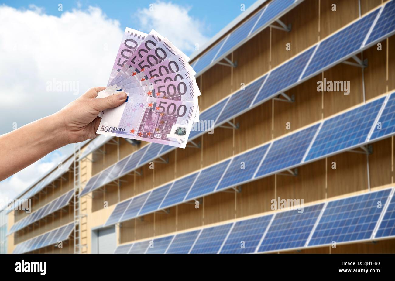 hands holding money over solar panels Stock Photo - Alamy