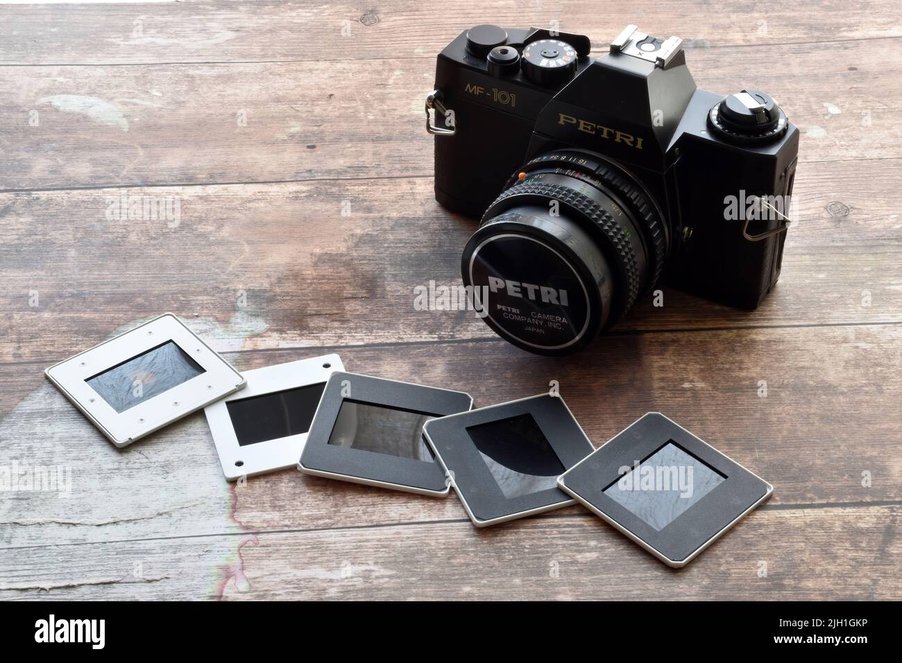 Vintage Petri camera with slides on wooden background. Retro style ...