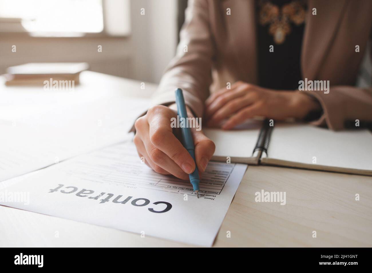Female hand with pen completing personal information on form. Business ...
