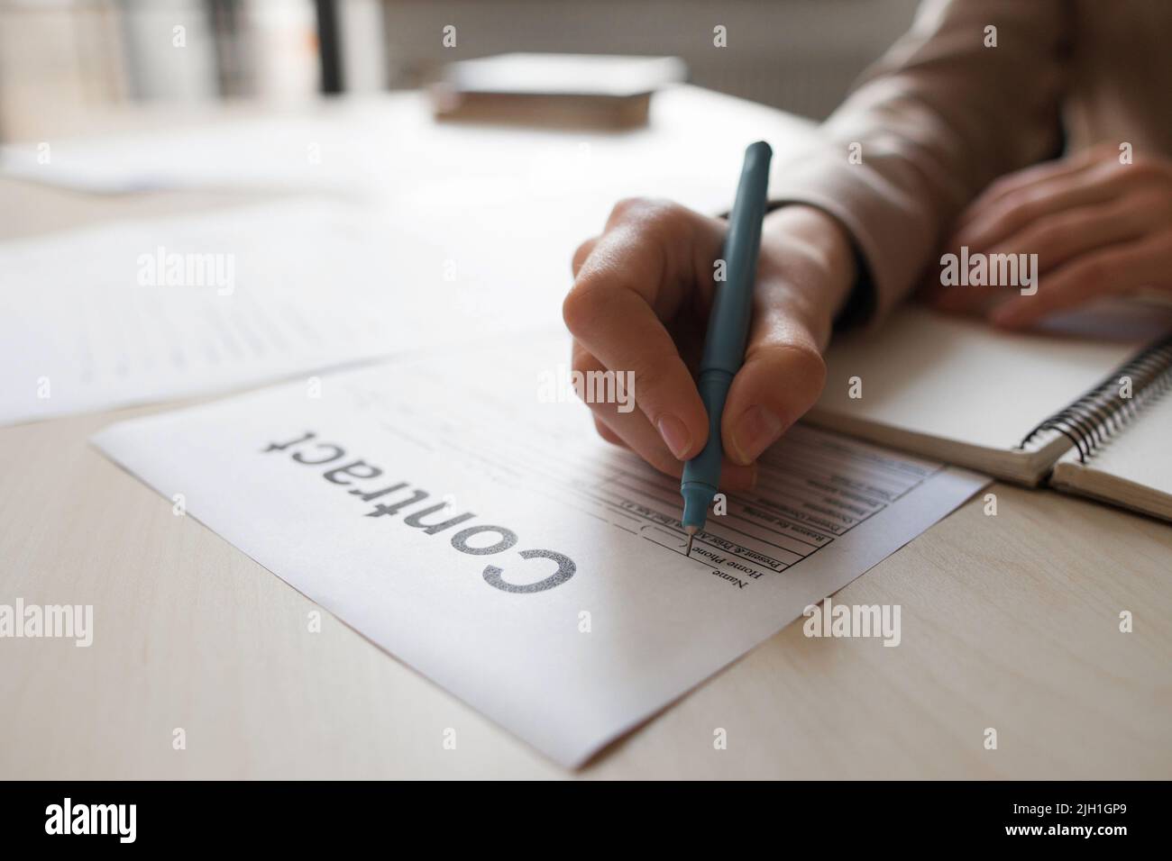 Business woman signing contract. Closeup of hand with pen, writing on ...