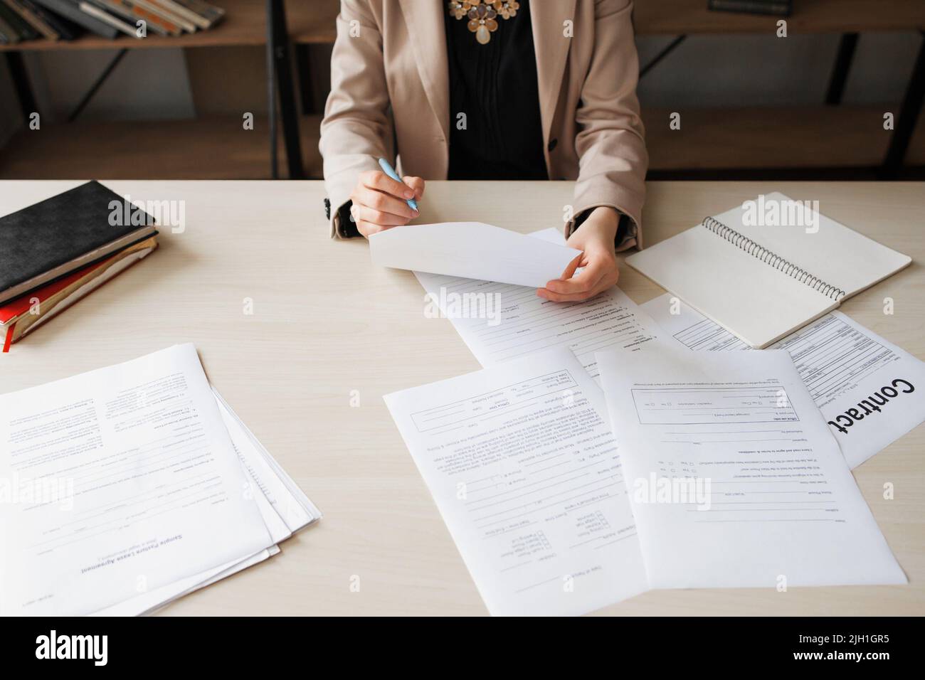 Unrecognizable woman reading document at her office desk, free space ...