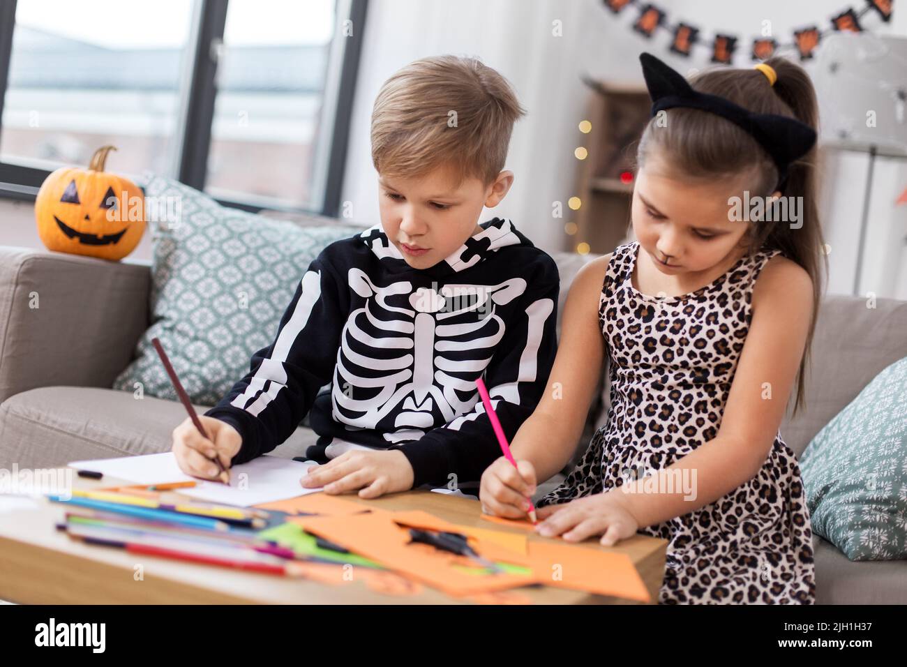 kids in halloween costumes doing crafts at home Stock Photo - Alamy