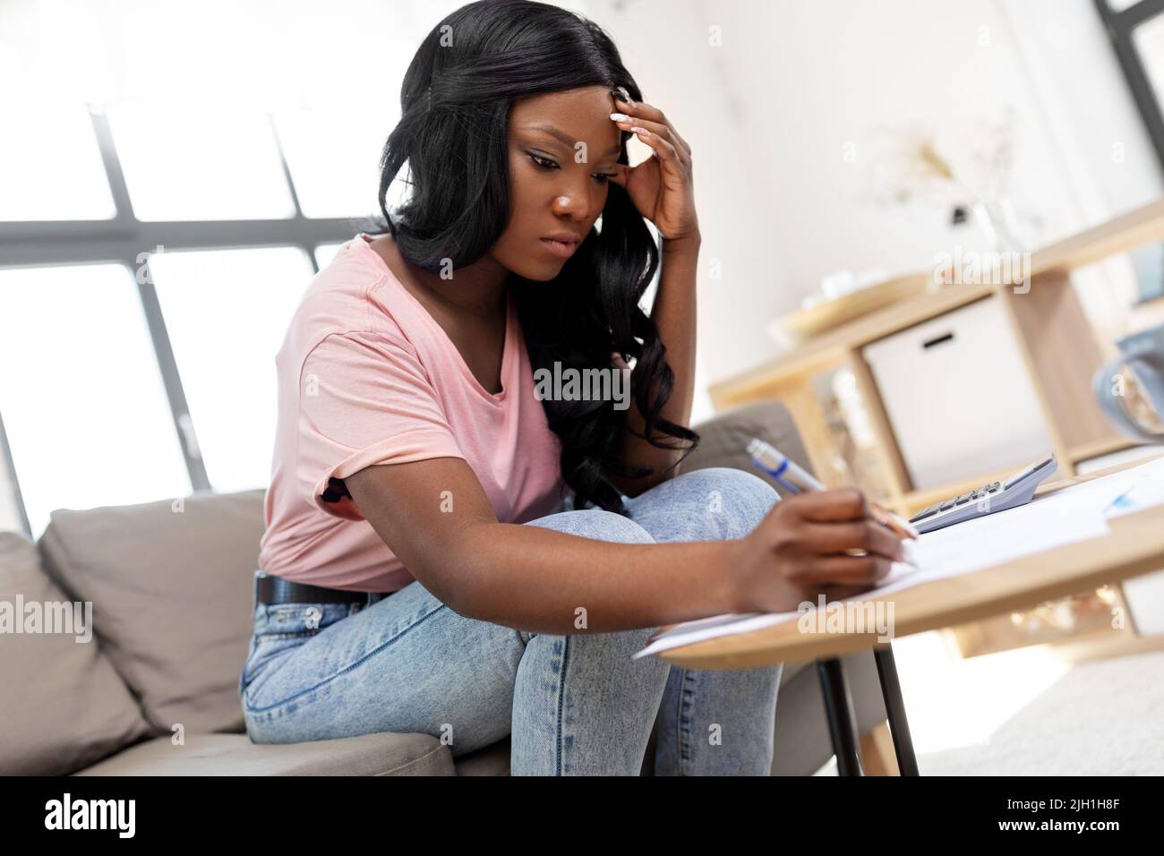 african woman with papers and calculator at home Stock Photo - Alamy