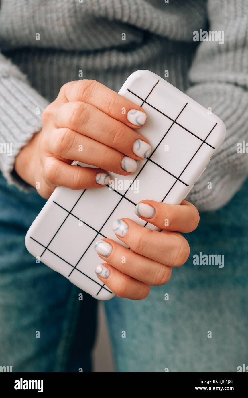 Stylish blue female nails holding mobile phone. Smartphone technology ...